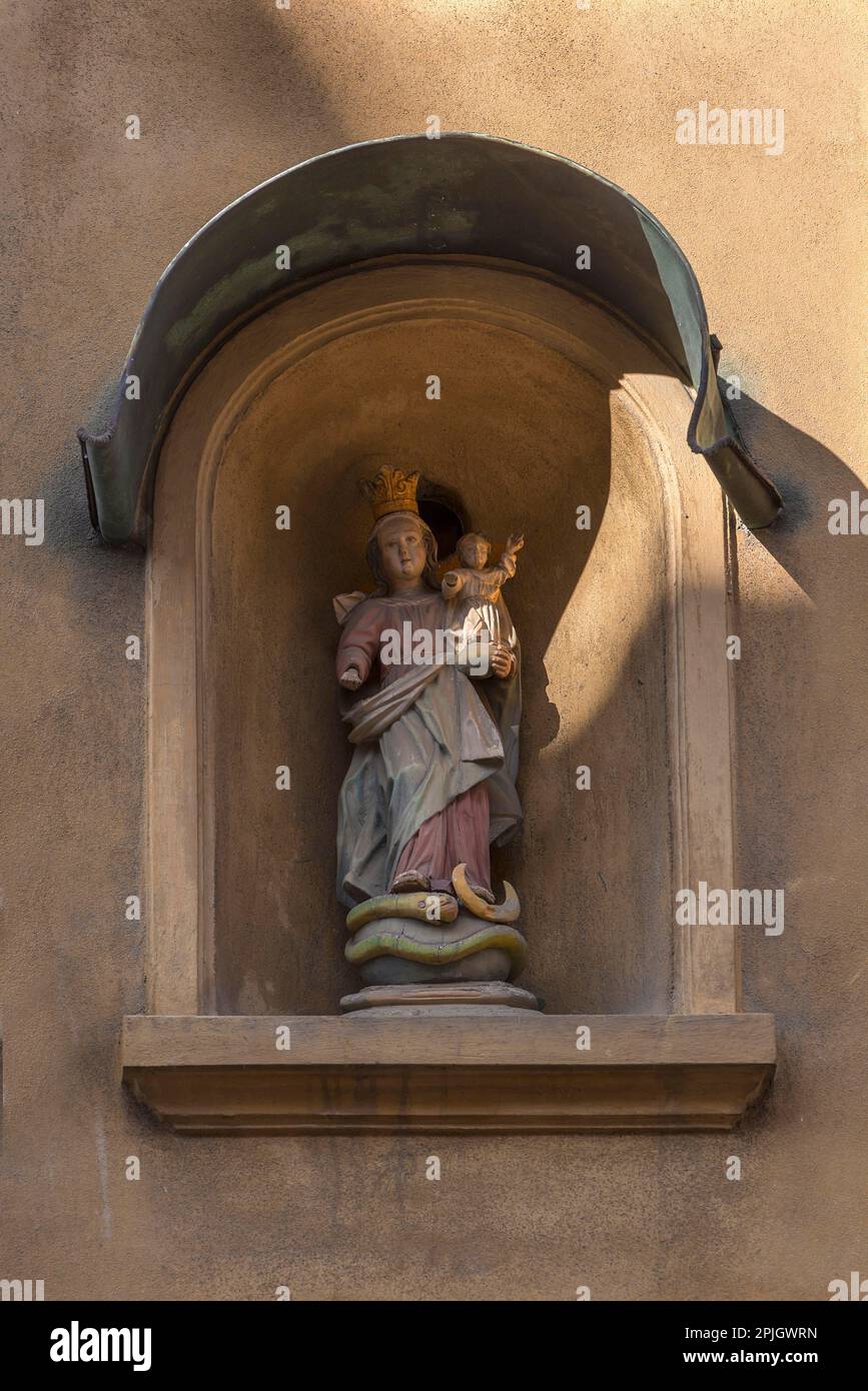 Sculpture of Maria immaculata with the infant Jesus in a niche on a ...