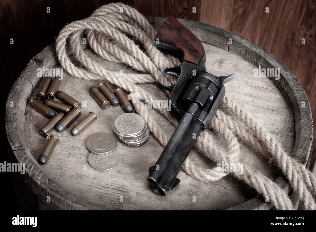 Old west revolver with cartridges and silver dollar coins on wooden ...