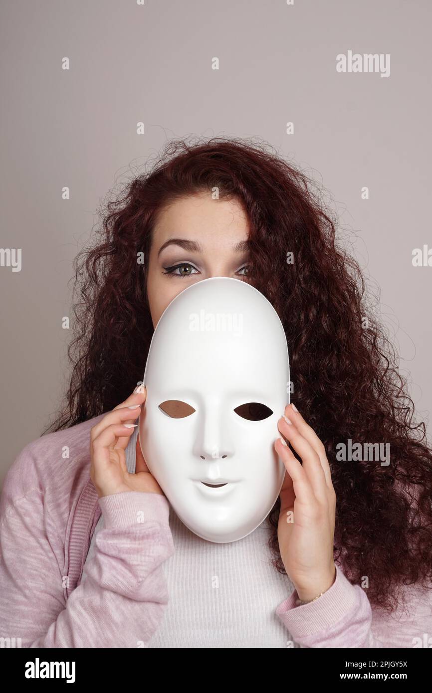 shy young woman taking off plain white mask Stock Photo - Alamy
