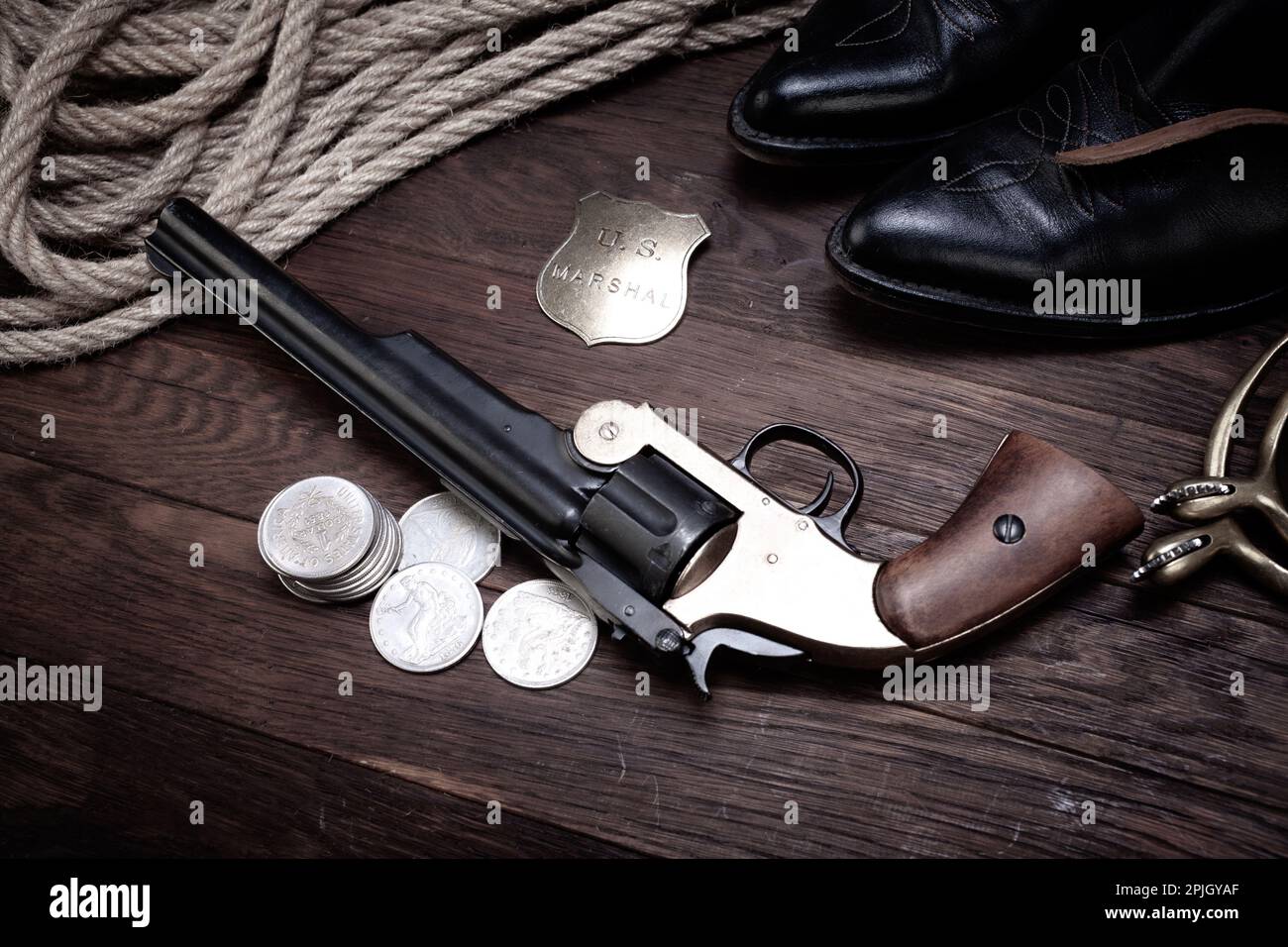 Old West revolver with U.S. Marshal badge and silver dollars with hat ...