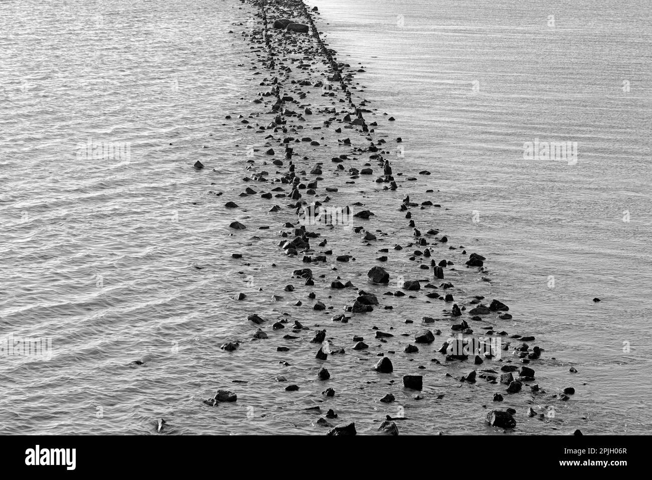 Stone groyne as coastal protection, Wadden Sea, black and white, North ...