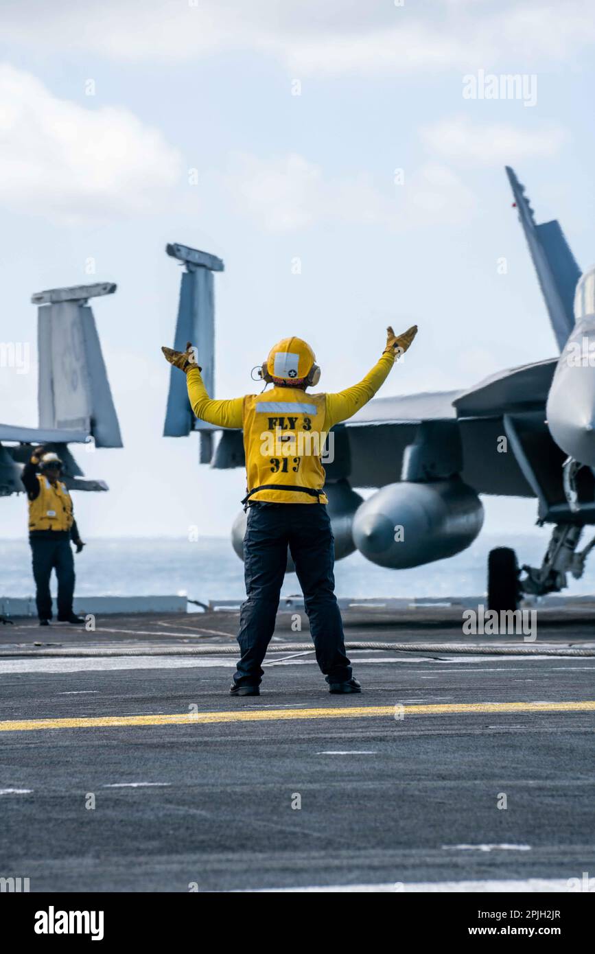 230330-N-AV223-1047 PACIFIC OCEAN (March 30, 2023) Sailor directs jets on the flight deck of ...
