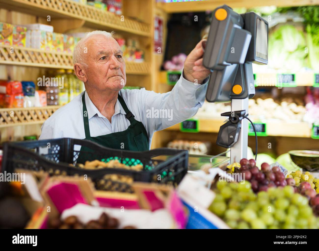 Old man cashier standing at counter in greengrocer Stock Photo - Alamy
