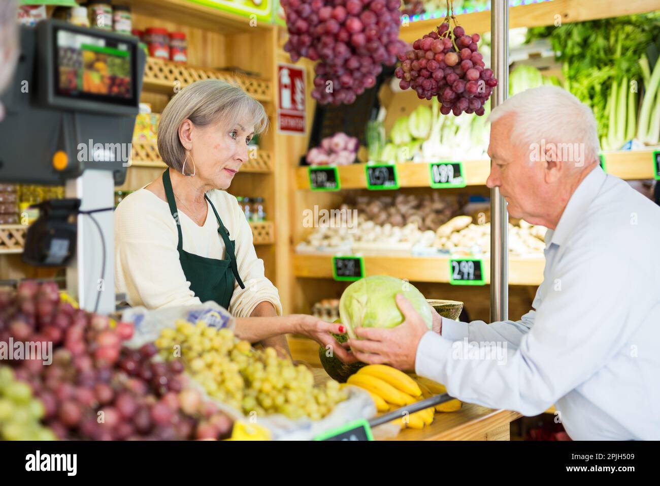 Senior cashier woman serving customer in greengrocer Stock Photo - Alamy