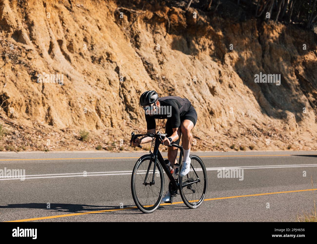 Professional road bike rider practicing on an empty road. Cyclist in a ...