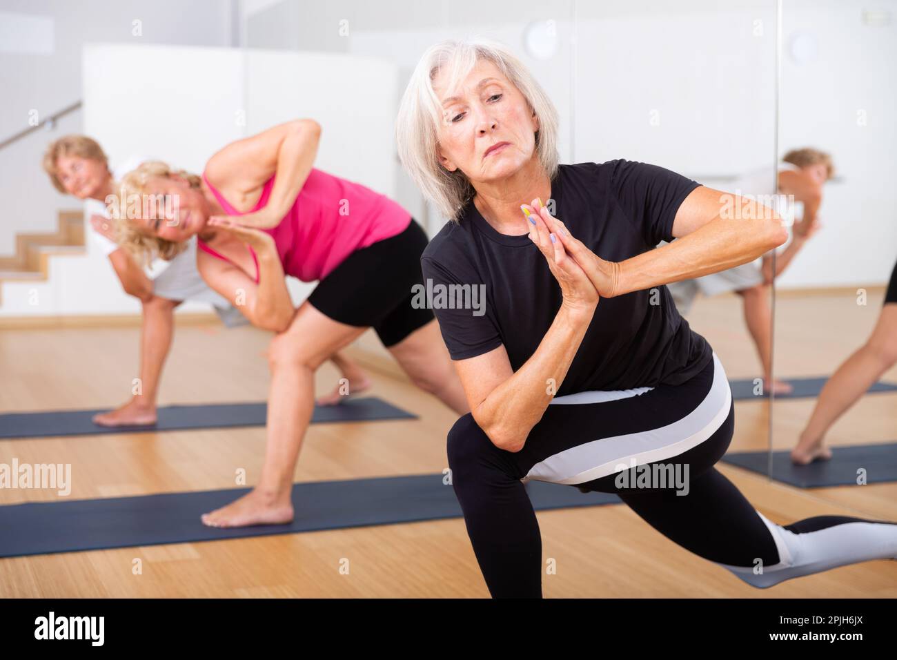 Mature women exercising yoga pose Stock Photo - Alamy
