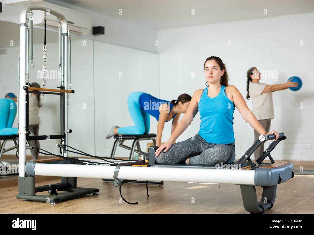 Young girl practicing pilates stretching exercises on reformer Stock ...