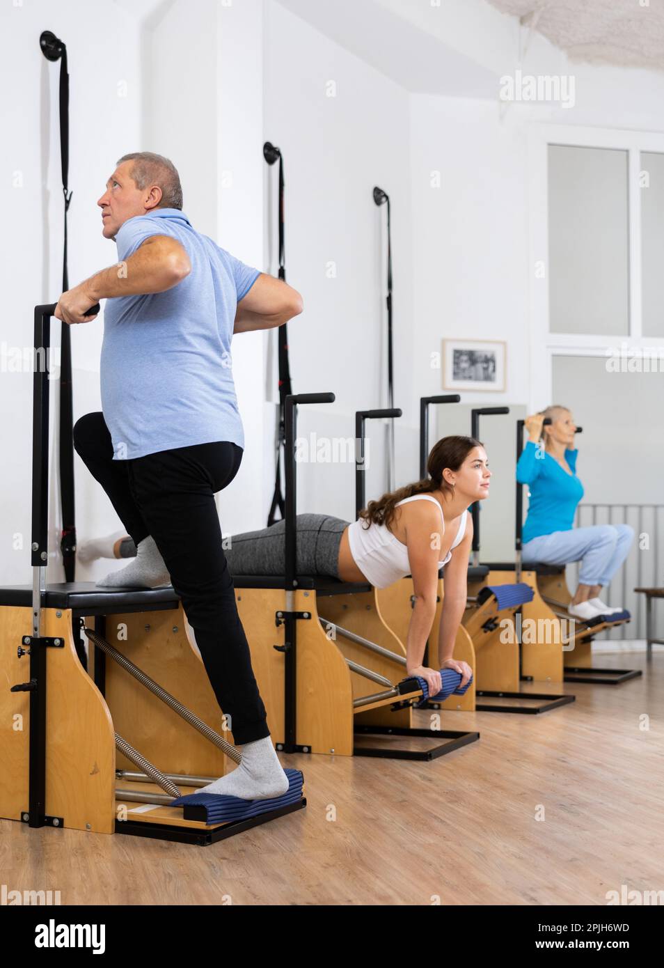 Concentrated old man wearing sportswear doing standing exercises on ...
