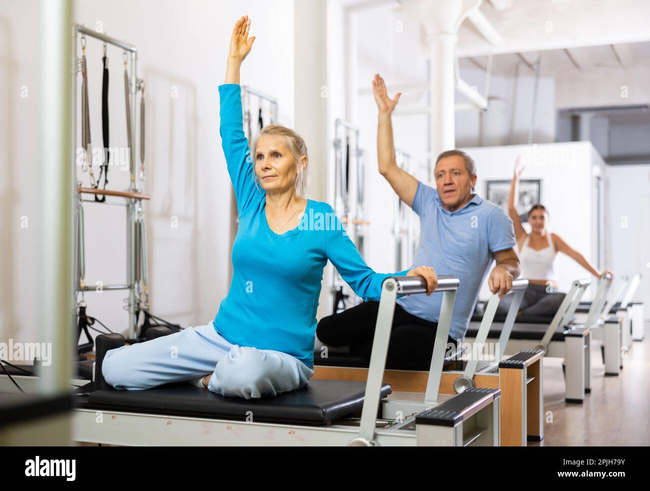 Active old woman stretching upper body practicing Pilates exercise in ...