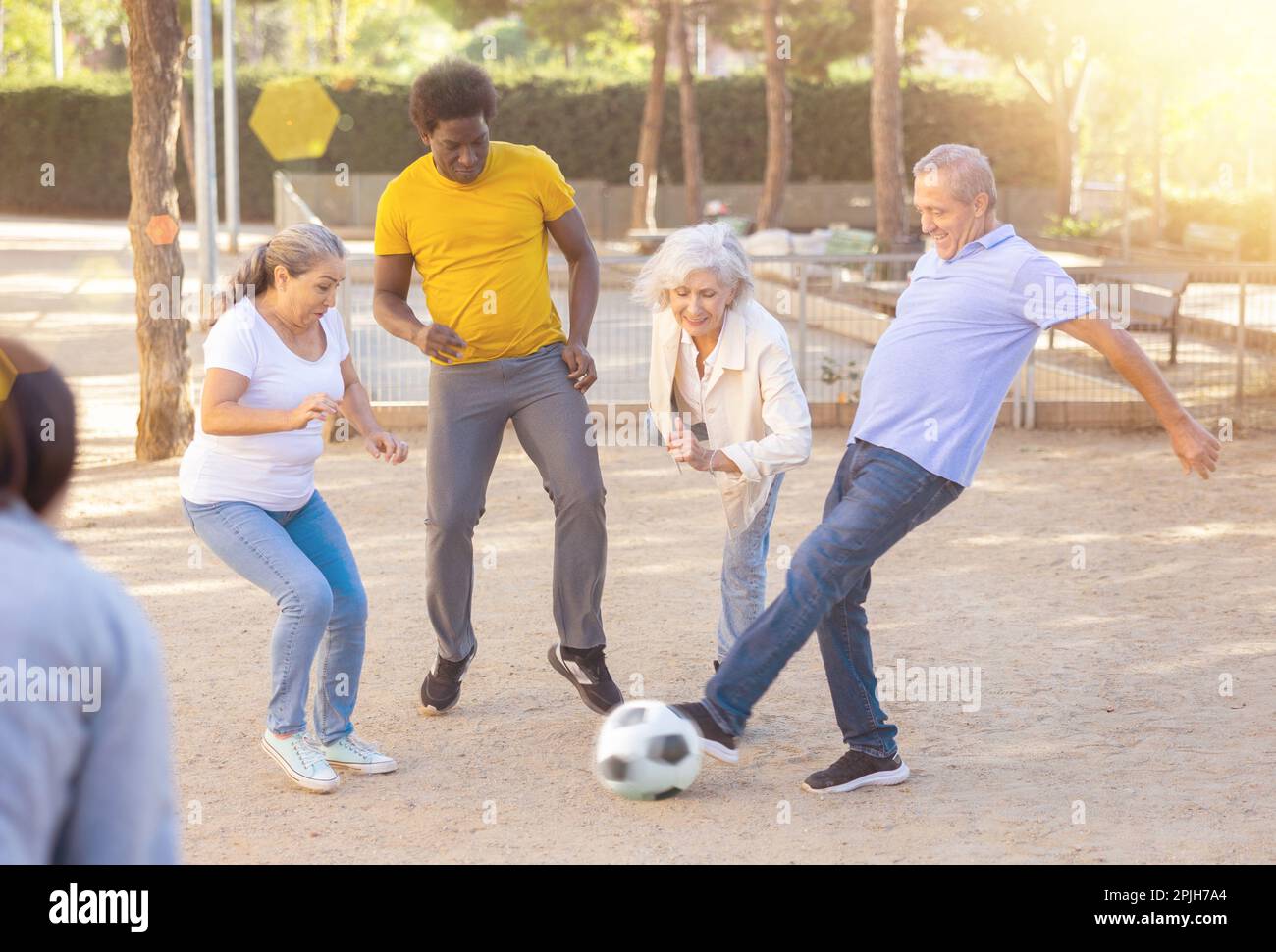 Cheerful group middle-aged and older adult people playing football game ...