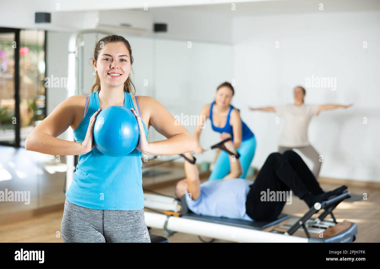 Girl doing chest muscles exercises with pilates ball Stock Photo - Alamy
