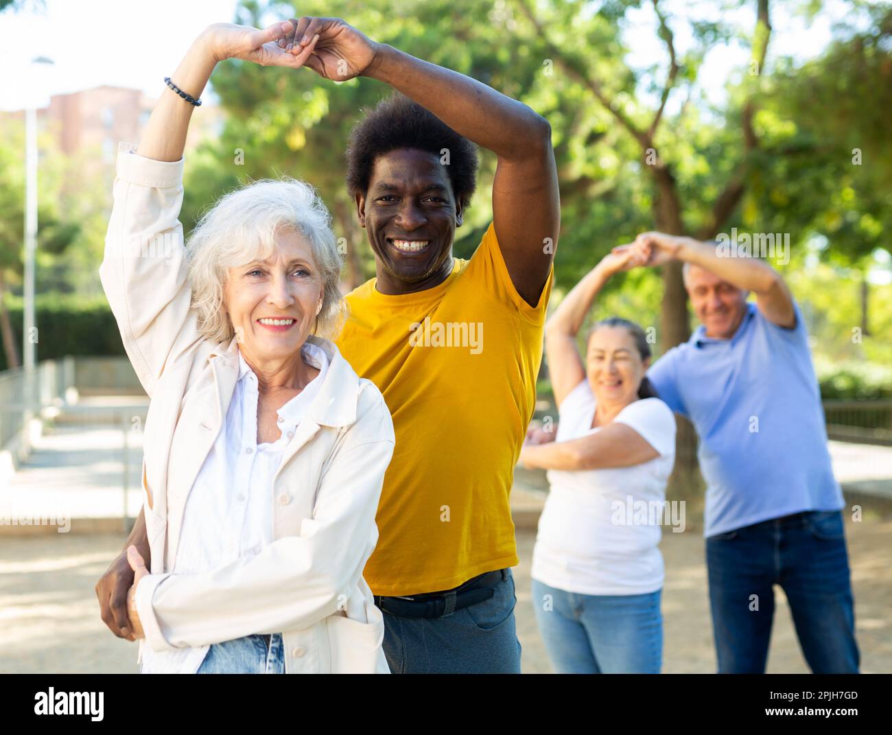 Cheerful multiracial middle aged and older adults enjoying dancing in ...