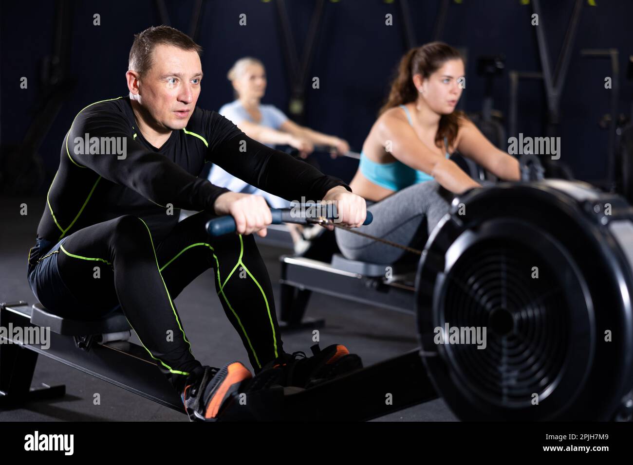 Athlete is engaged in the gym, man works on rowing simulator Stock ...