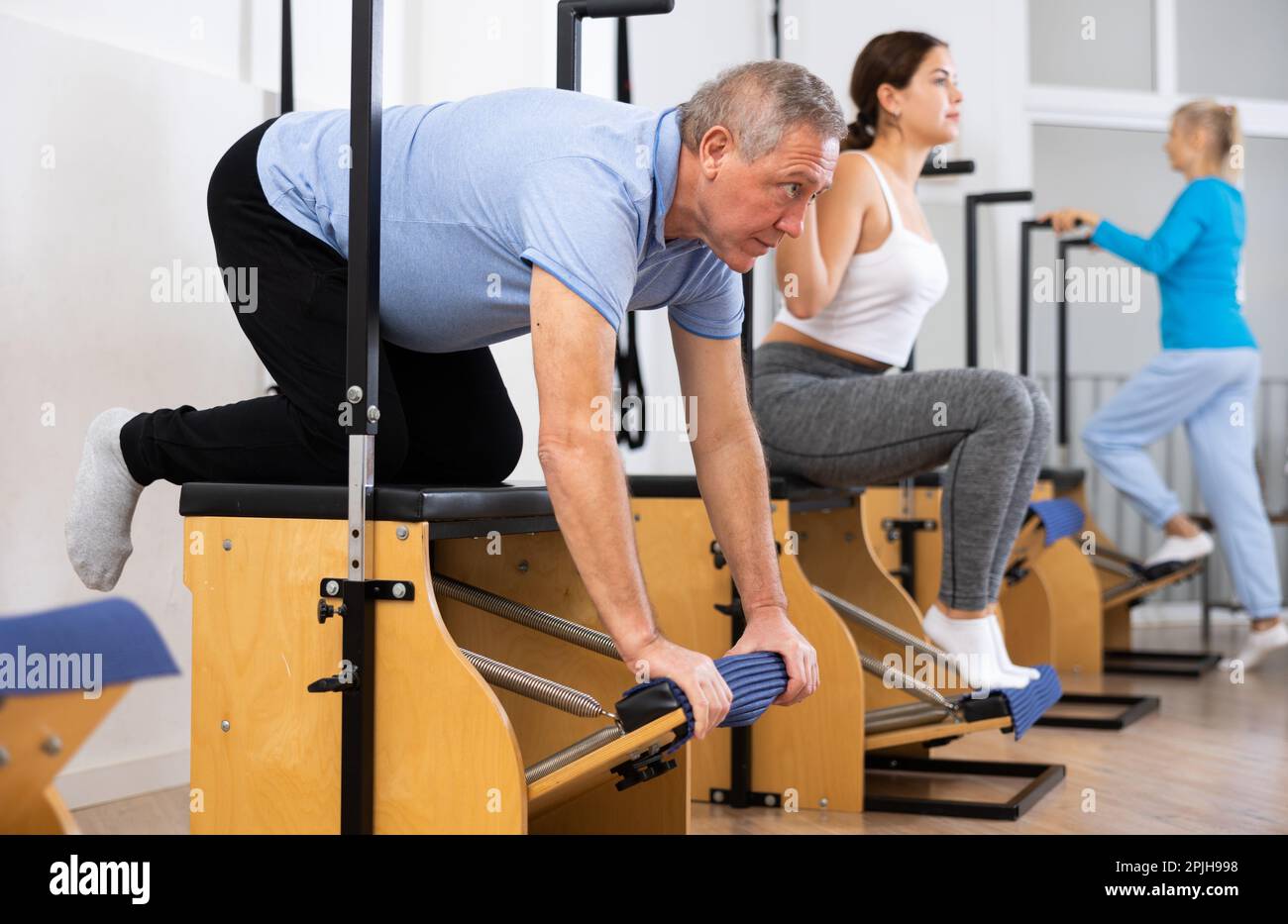 Senior male pensioner training hands and lower back while laying on ...