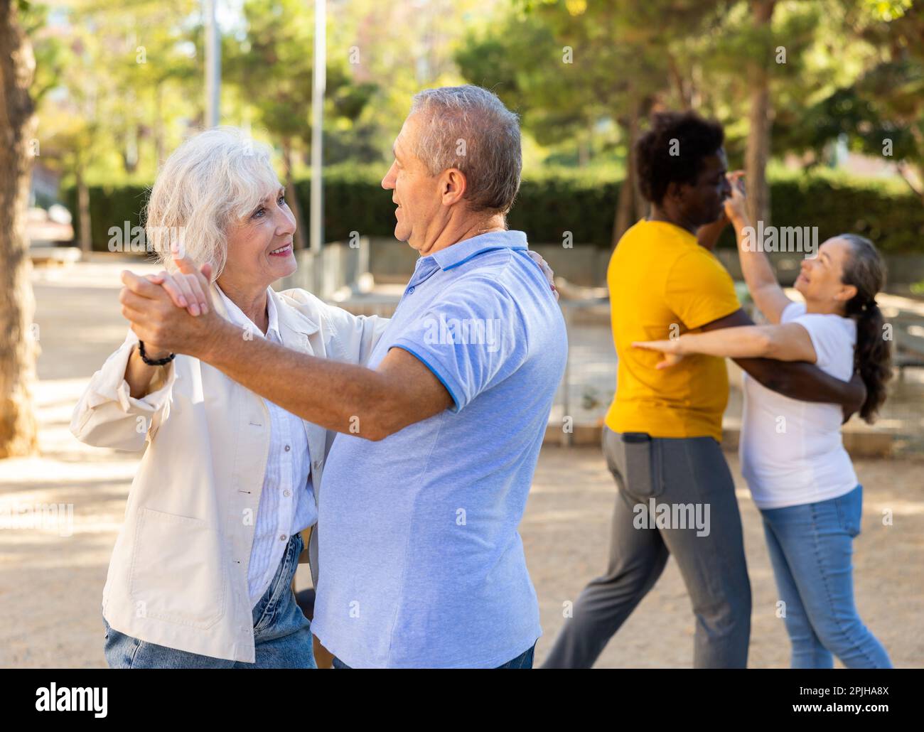 Cheerful multiracial middle aged and older adults enjoying dancing in ...