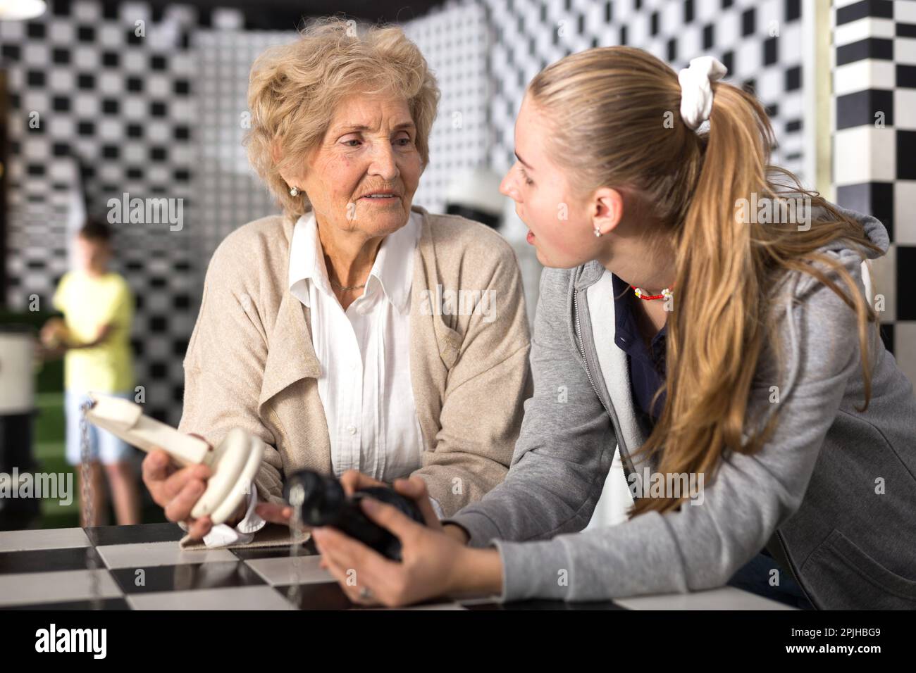 Grandmother and granddaughter solving chess conundrum in escape room ...