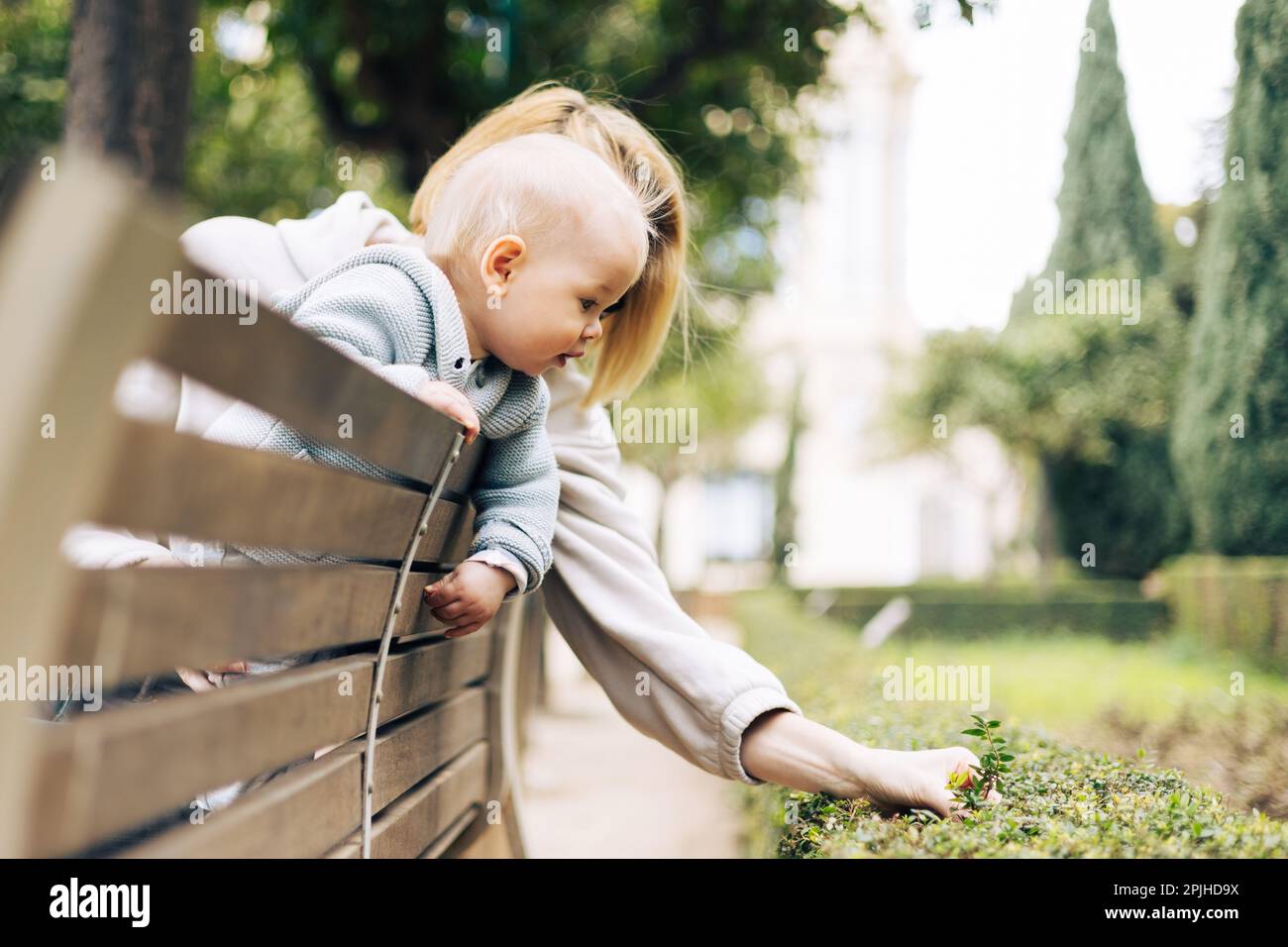 Young mother with her cute infant baby boy child leaning over back of ...