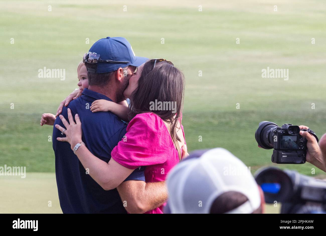 Corey Conners holds his daughter, Reis Olivia, as he gets a kiss from ...