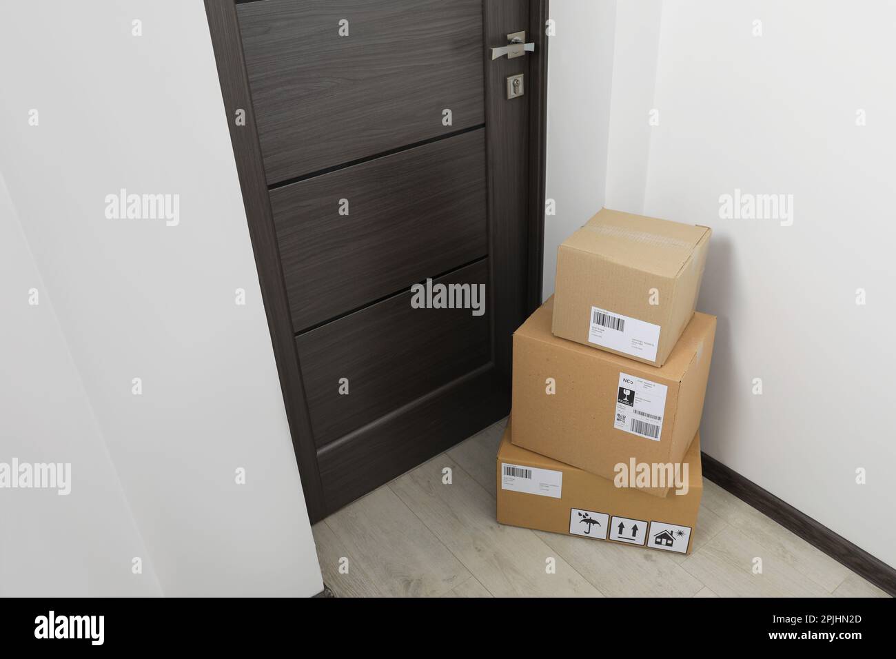 Cardboard boxes on floor near entrance. Parcel delivery service Stock ...