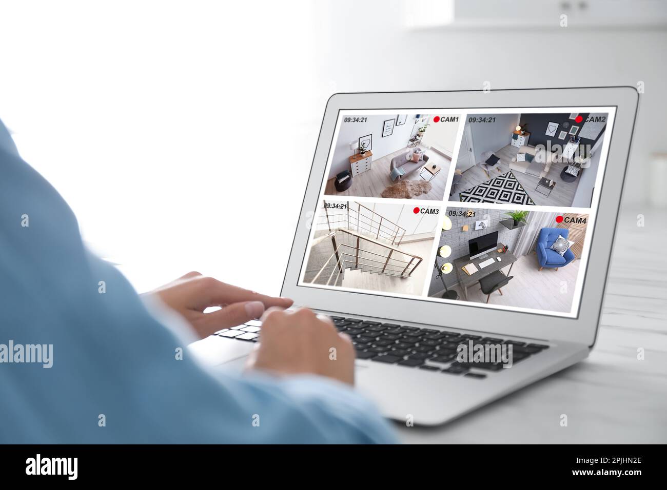 Woman monitoring modern CCTV cameras at white table, closeup. Smart ...