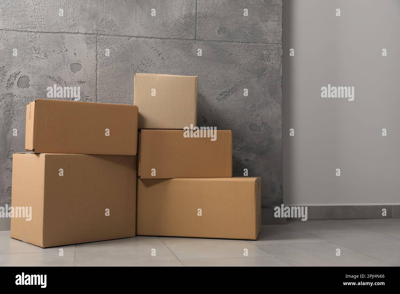 Many closed cardboard boxes on floor indoors. Delivery service Stock ...