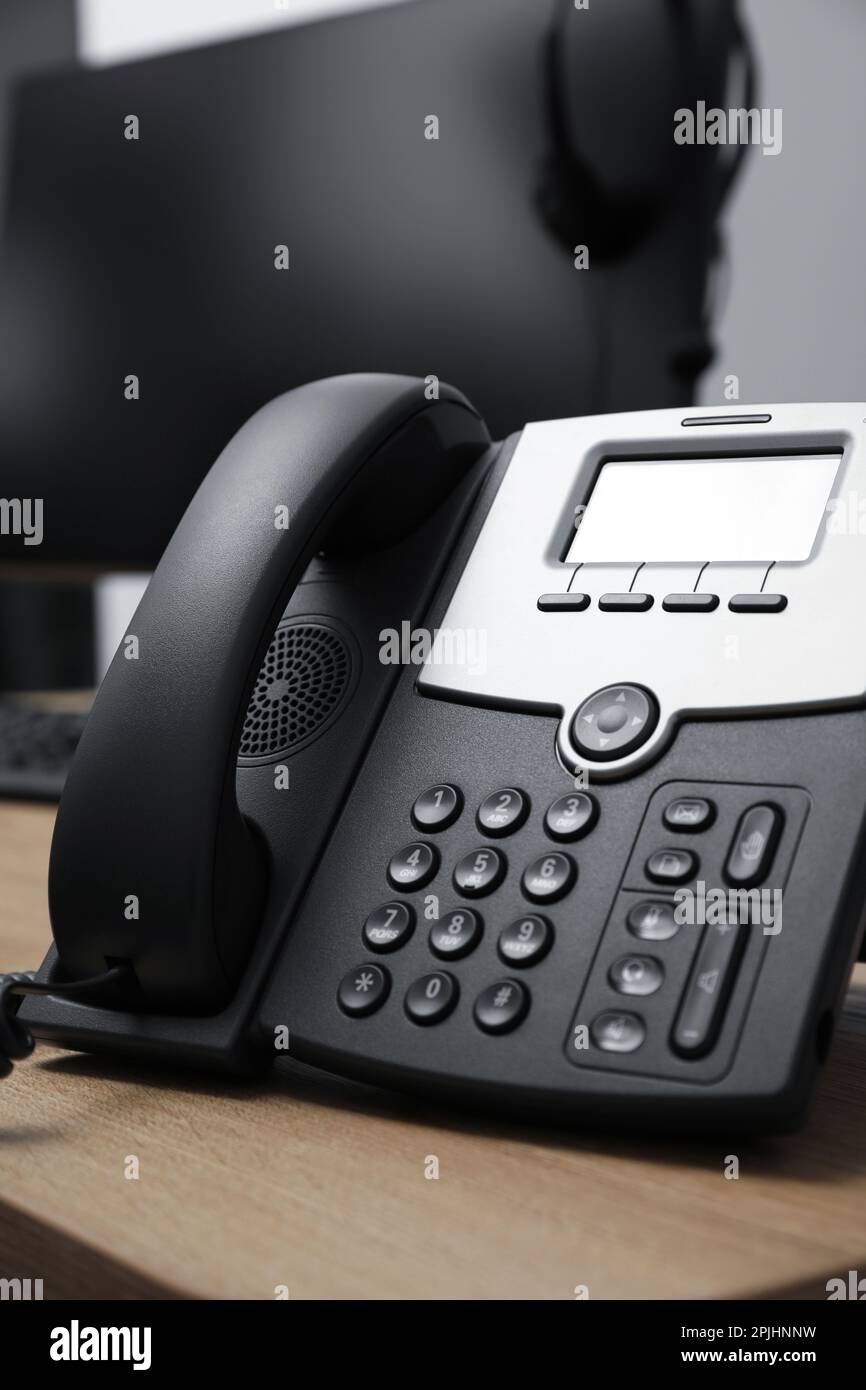 Stationary phone on wooden desk in office. Hotline service Stock Photo ...