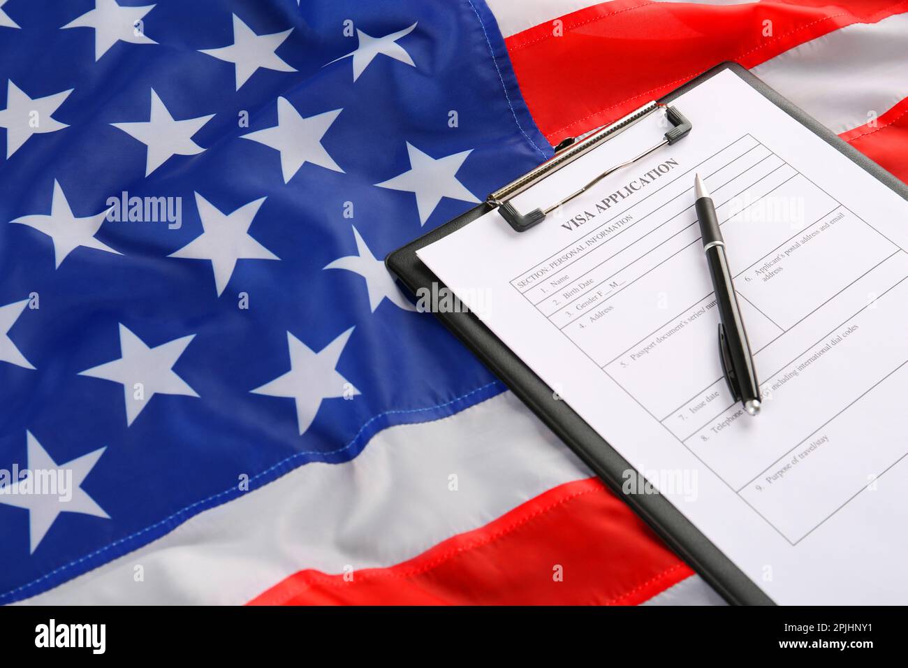 Visa application form and pen on American flag. Immigration to USA ...