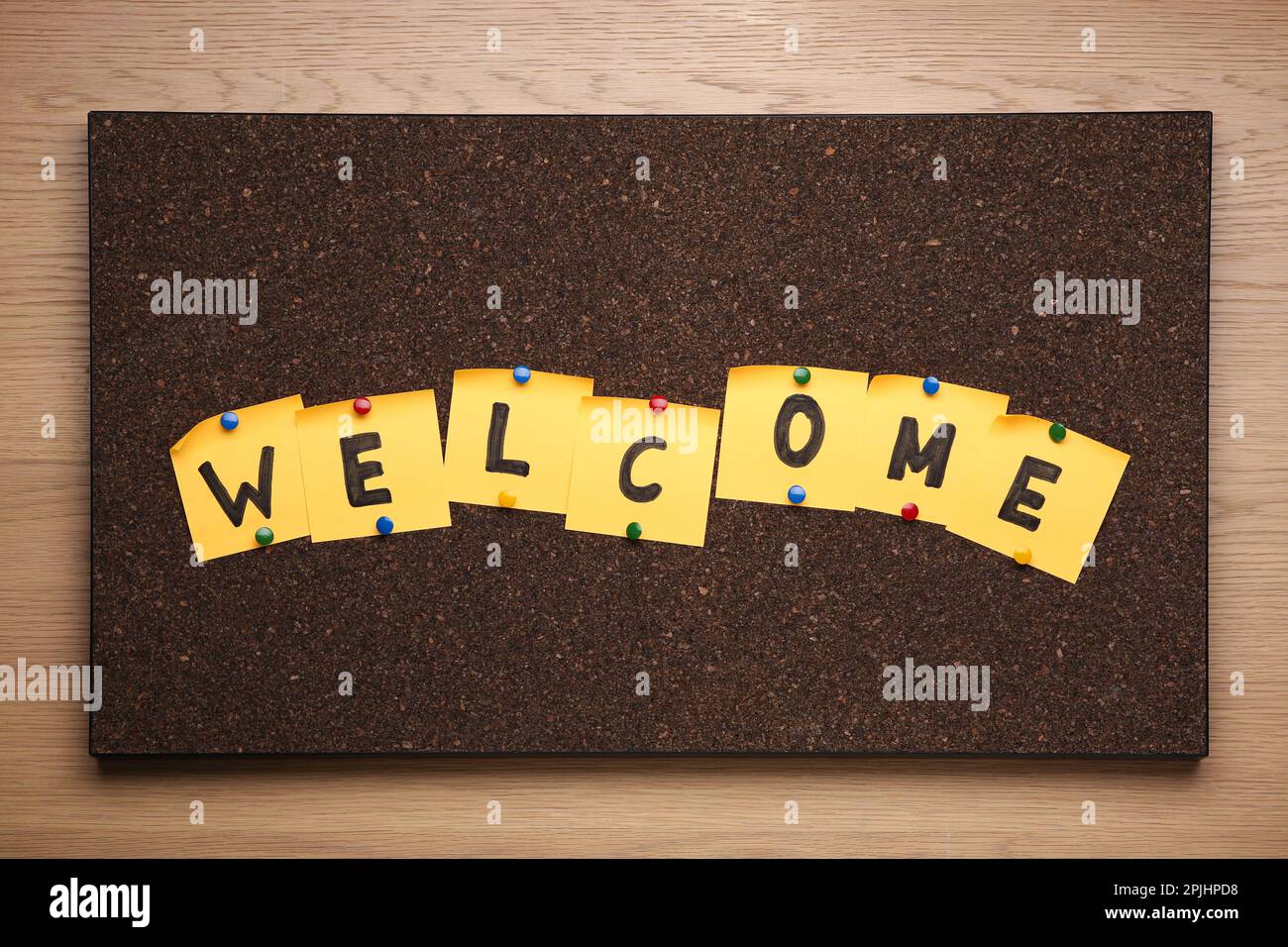 Corkboard with word Welcome made of paper notes on wooden background ...
