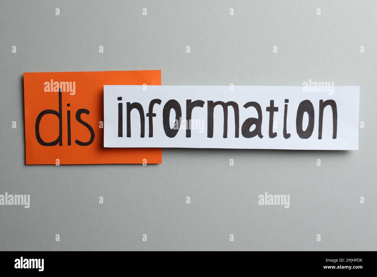 Word DISINFORMATION made with paper pieces on light grey background ...