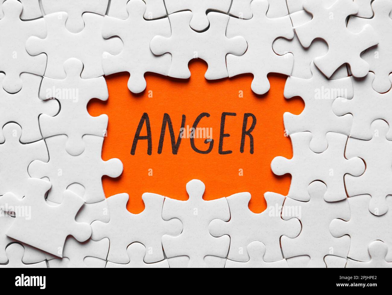 White puzzle pieces and word ANGER written on orange background, flat ...