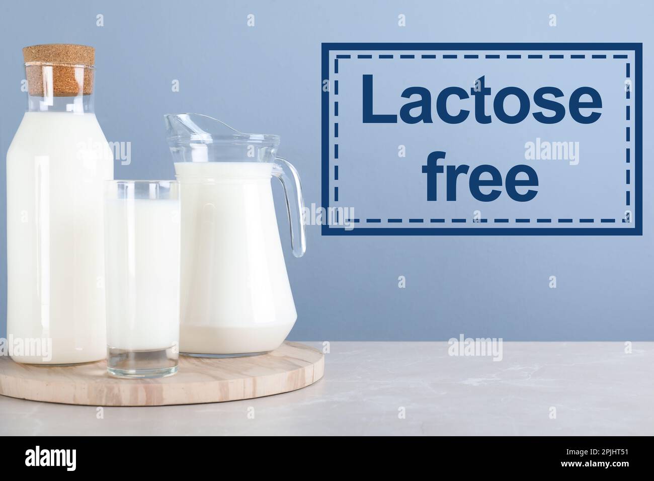 Fresh lactose free milk on white table against light blue background ...