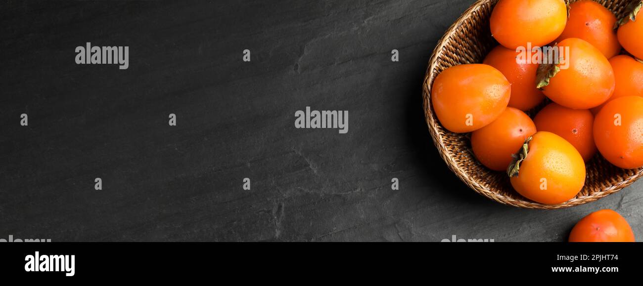 Delicious fresh persimmons on black slate table, top view with space ...