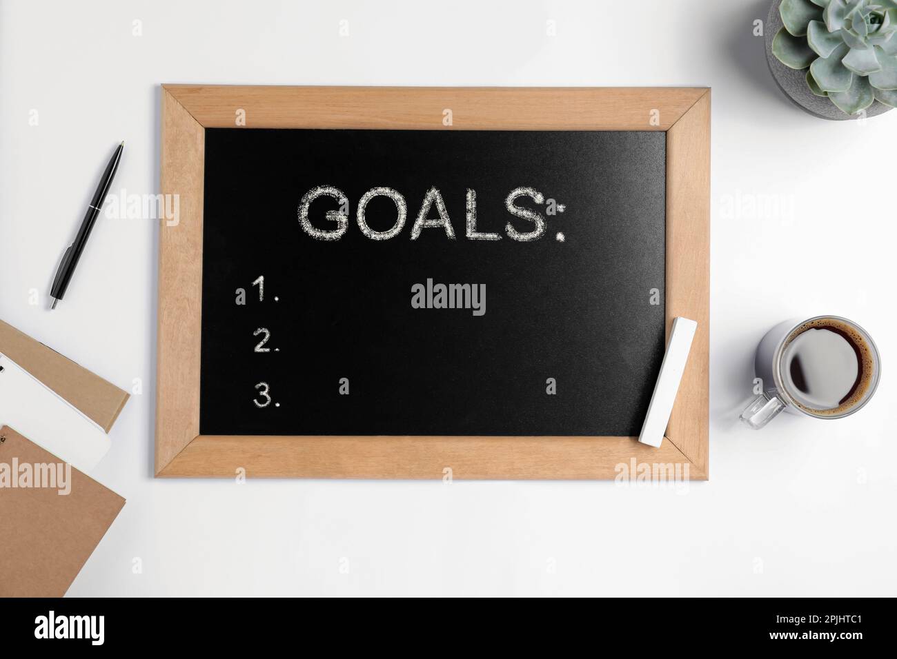 Blackboard with word GOALS and empty checklist on white background ...