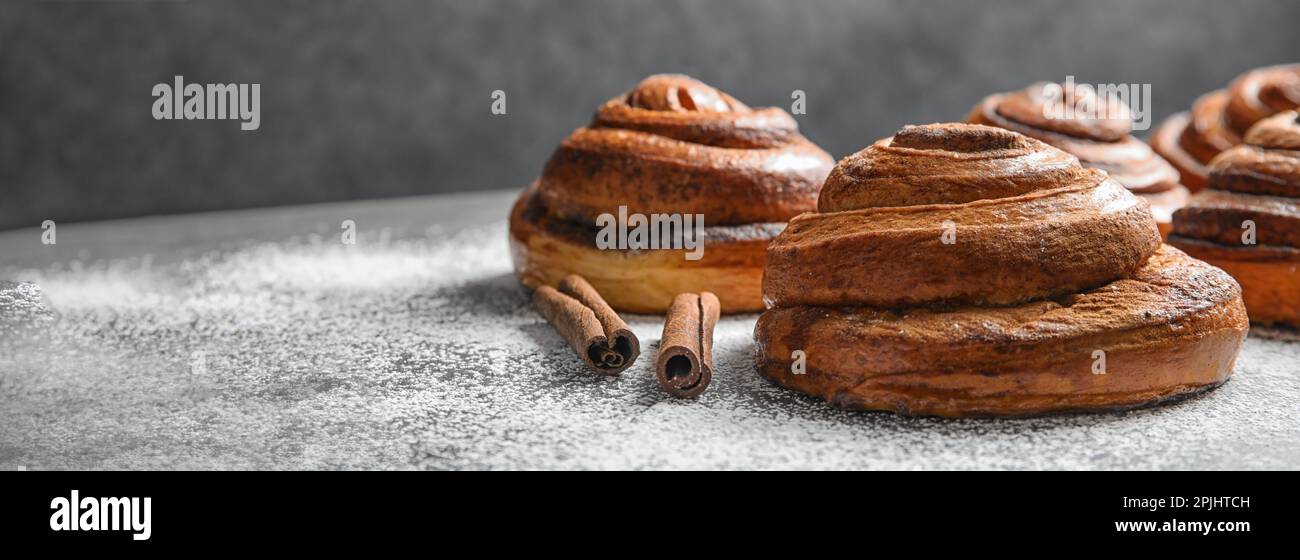 Cinnamon rolls and sugar powder on table, space for text. Banner design ...