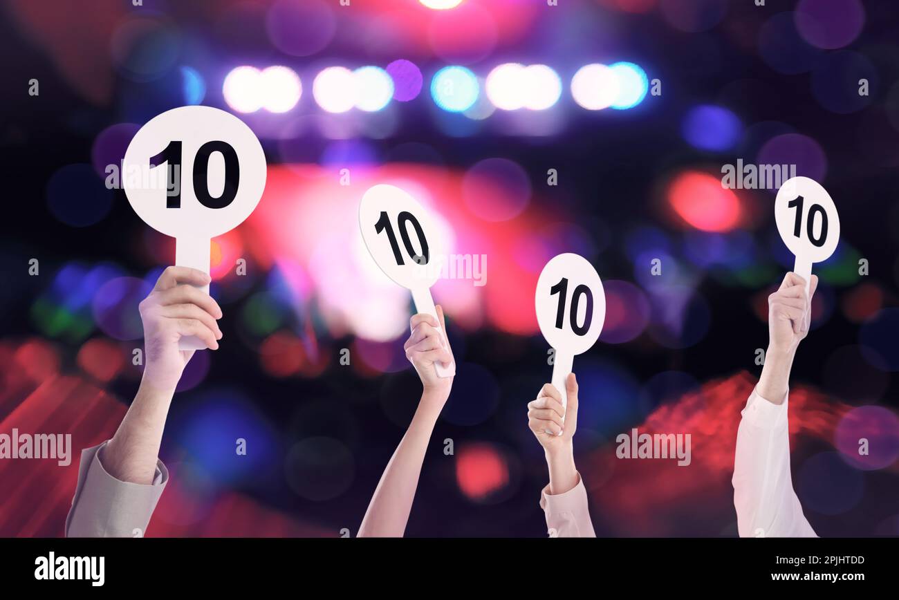 Panel of judges holding signs with highest score against blurred ...