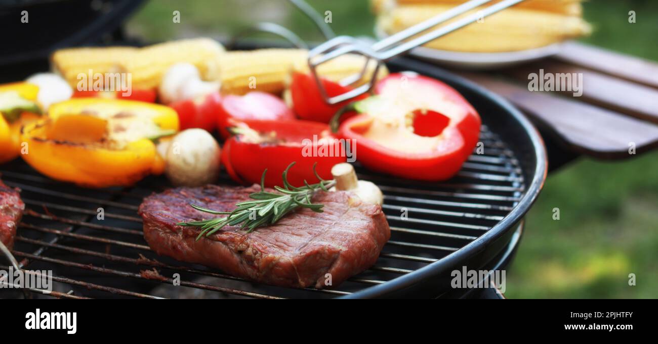 Cooking meat and vegetables on barbecue grill outdoors, closeup. Banner ...