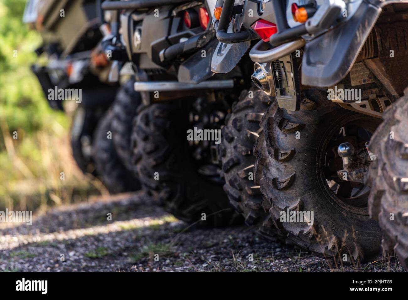 Close-up tail view of ATV quad bike on dirt country road. Dirty wheel ...