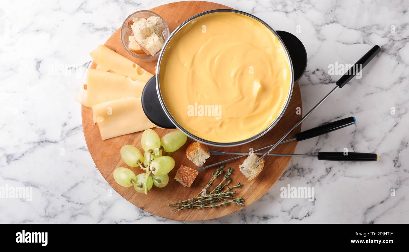 Flat lay composition with pot of delicious cheese fondue on white ...