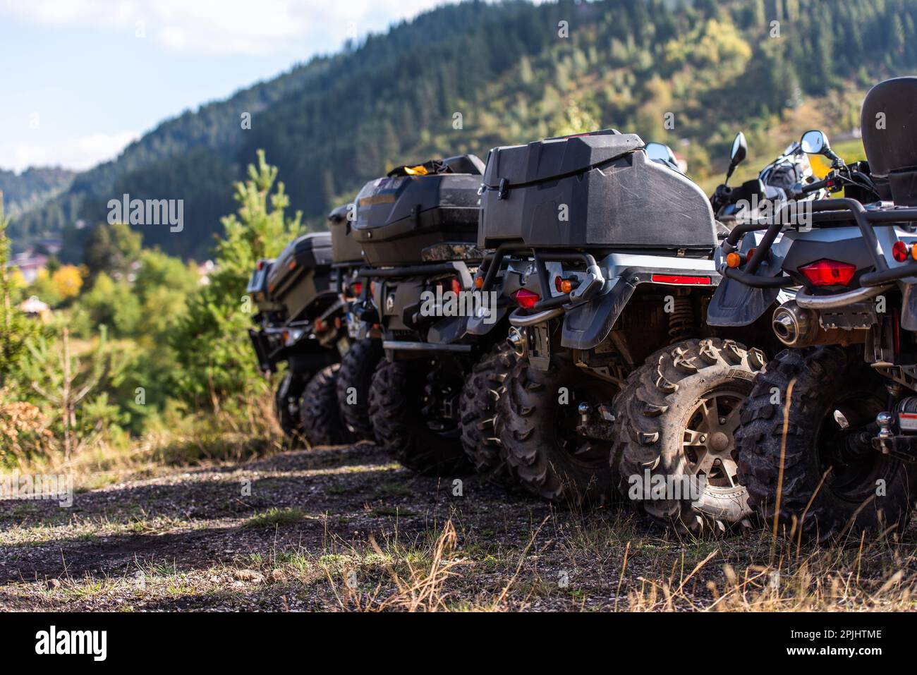 Close-up tail view of ATV quad bike on dirt country road. Dirty wheel ...