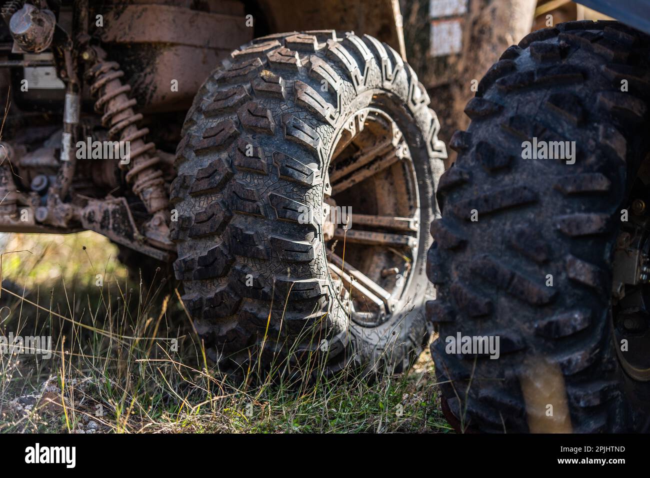 Close-up tail view of ATV quad bike on dirt country road. Dirty wheel ...