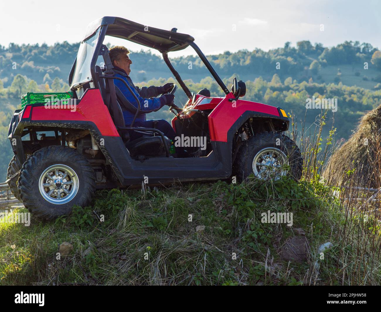 A man driving a quad ATV motorcycle through beautiful meadow landscapes Stock Photo - Alamy