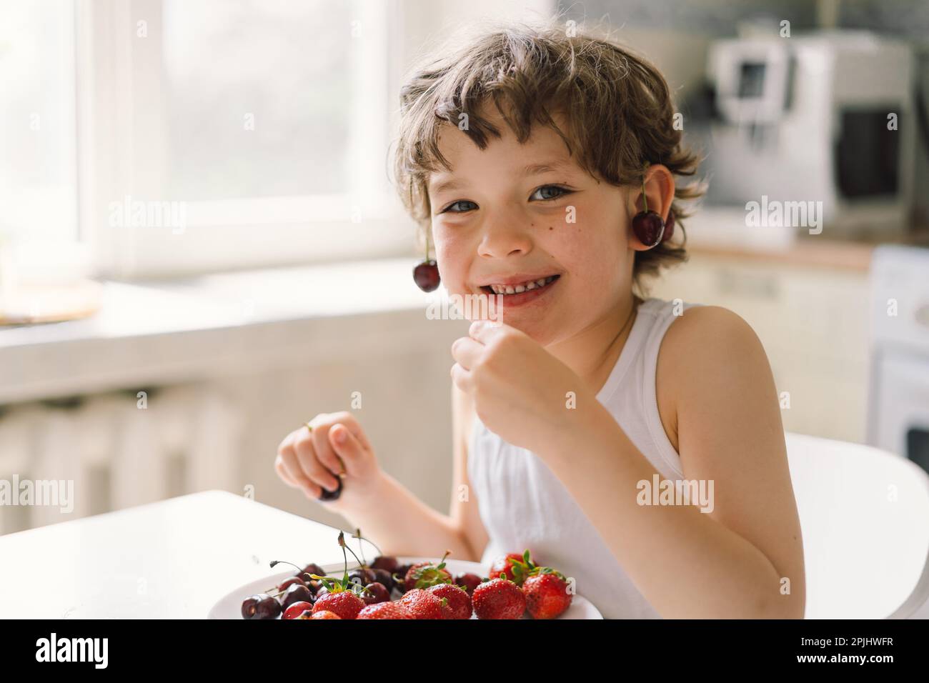 Cute beautiful little boy eating fresh cherry and strawberry Stock ...