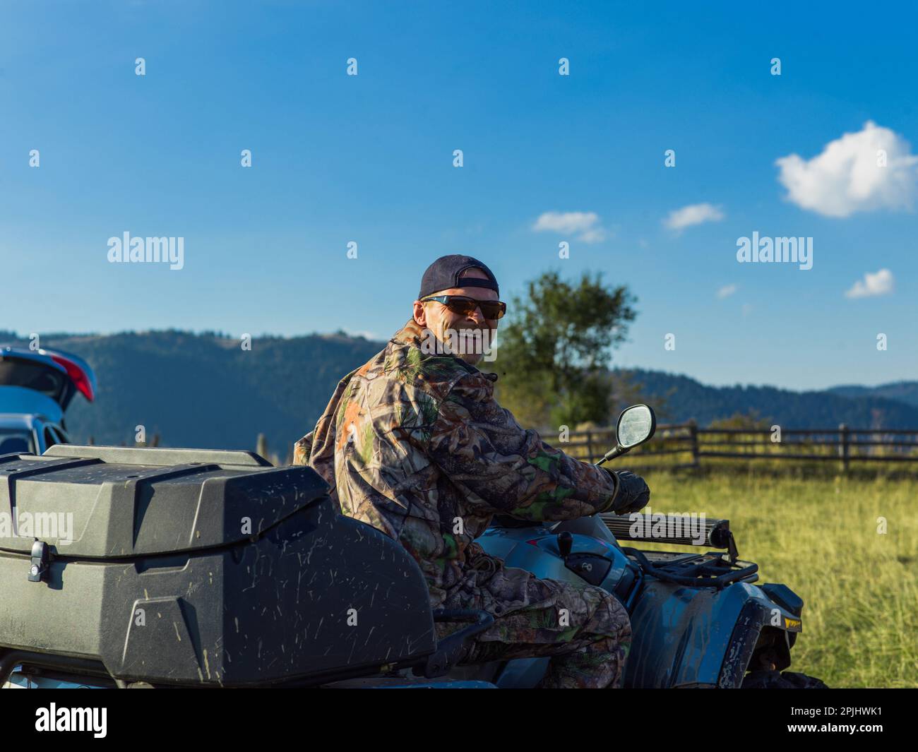 A man driving a quad ATV motorcycle through beautiful meadow landscapes Stock Photo - Alamy