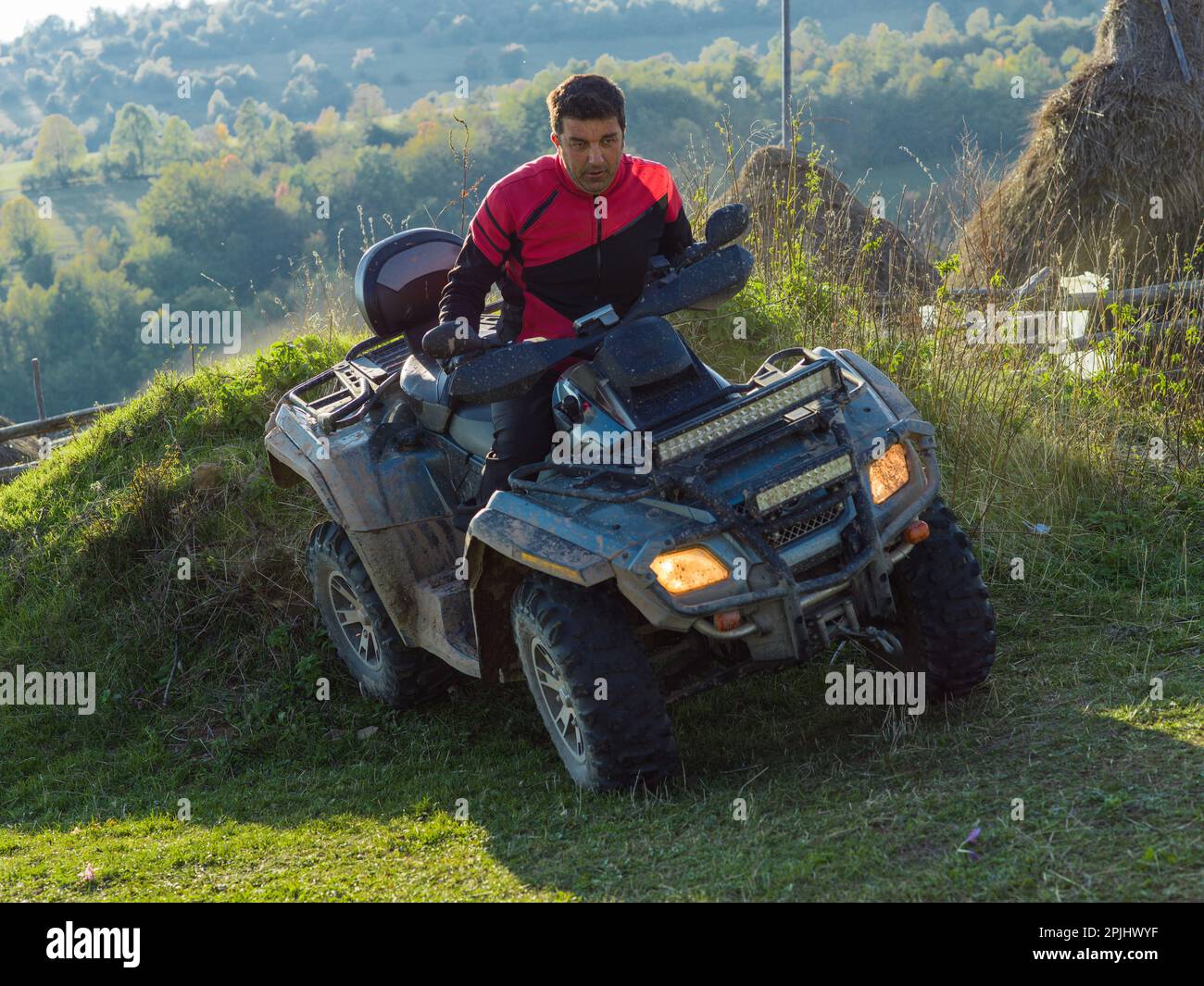 A man driving a quad ATV motorcycle through beautiful meadow landscapes Stock Photo - Alamy