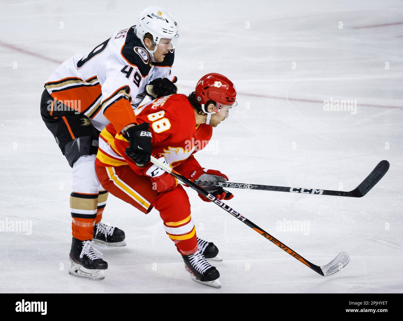 Anaheim Ducks forward Max Jones, left, checks Calgary Flames forward ...