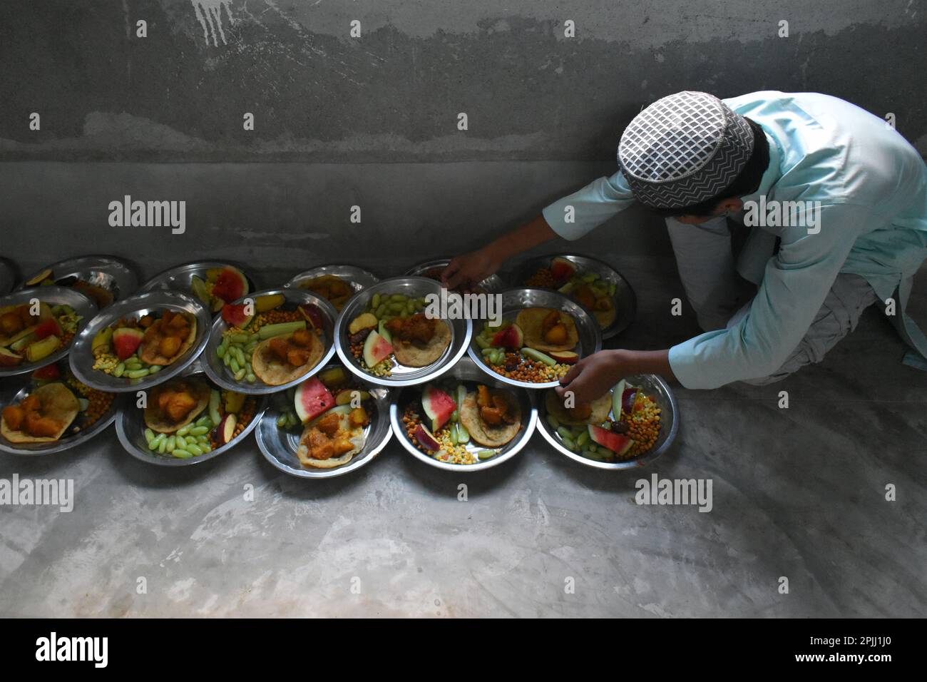 Kolkata, India. 02nd Apr, 2023. A Muslim boy prepares plates of food ...