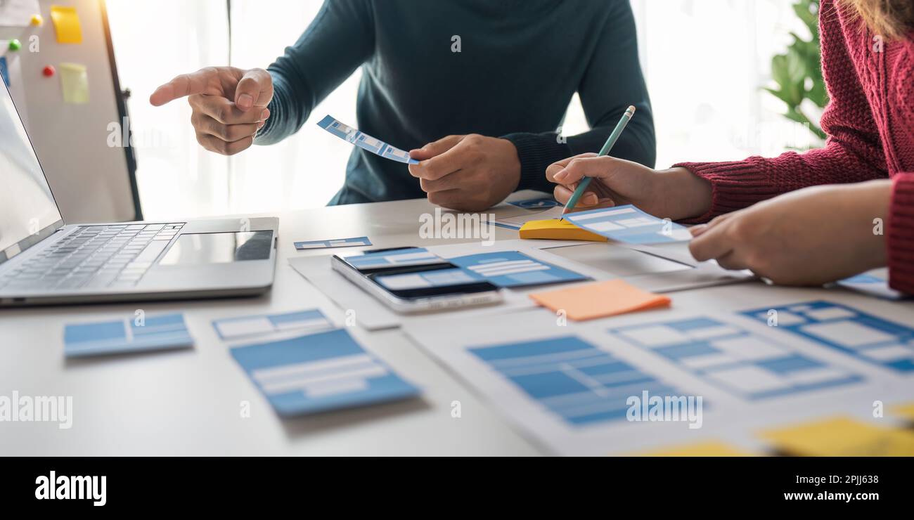 Close up ux developer and ui designer brainstorming about mobile app ...