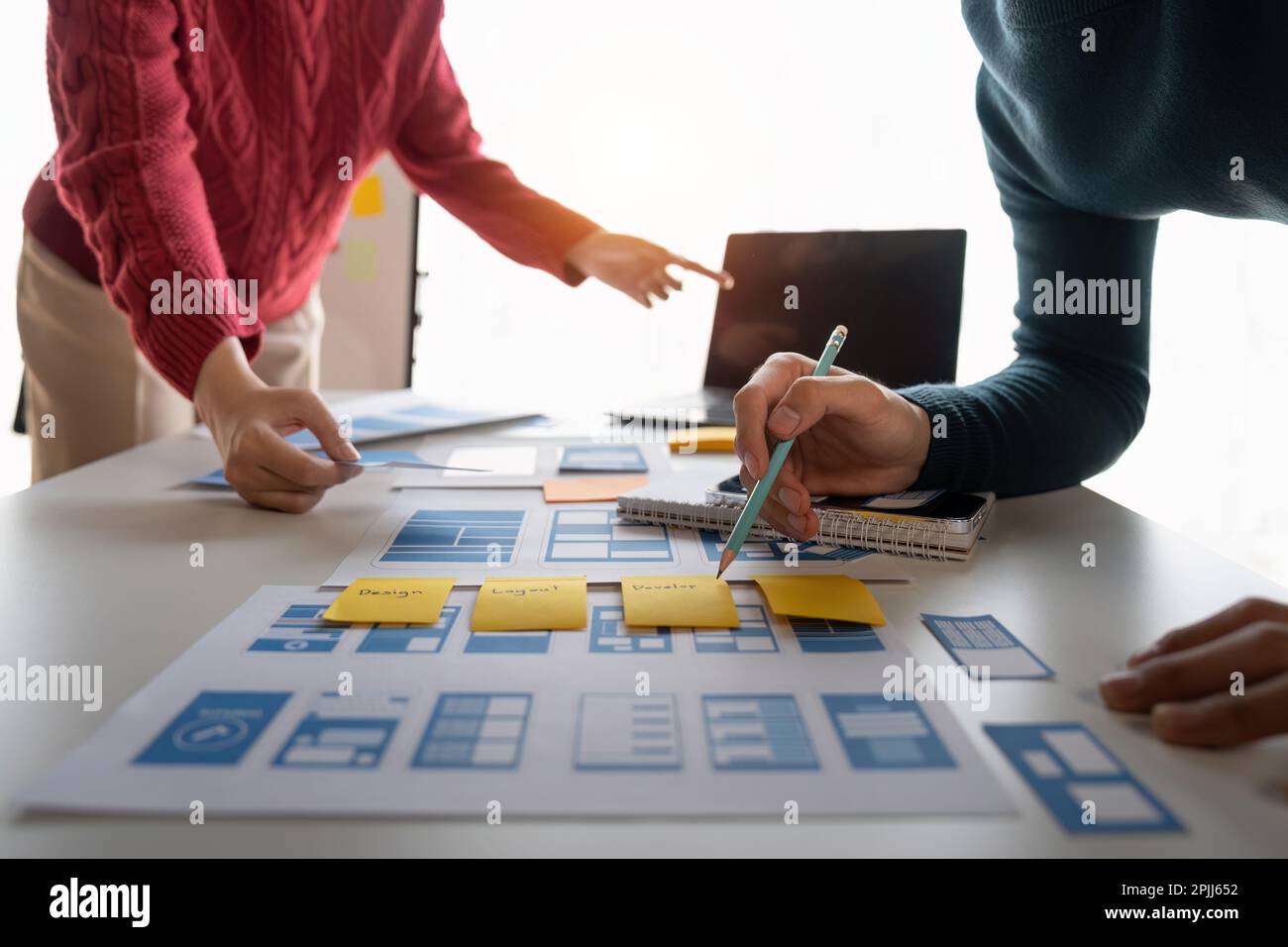 Close up ux developer and ui designer brainstorming about mobile app ...