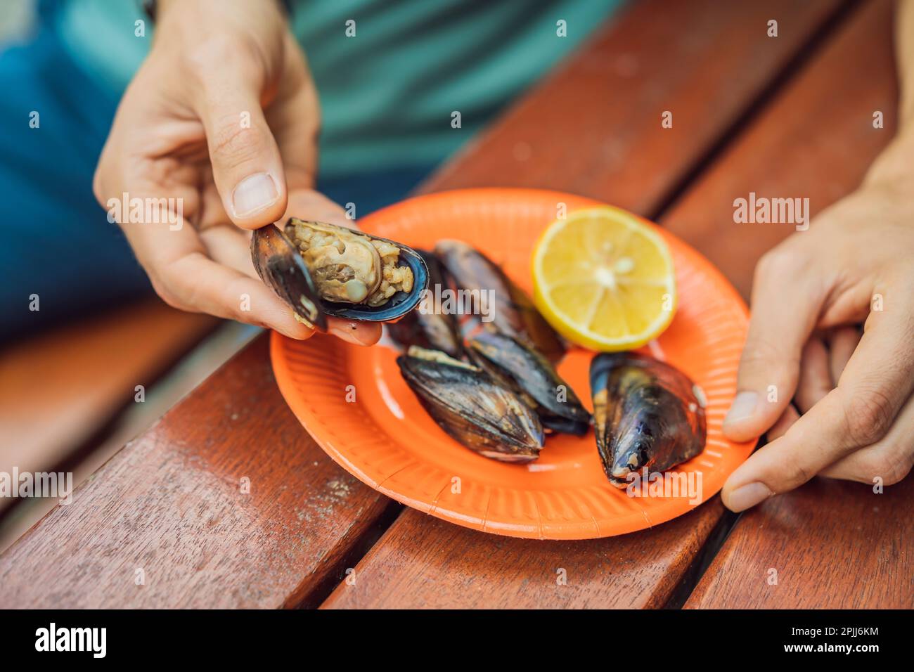 Heap of mussels in shells stuffed with rice. Man is going to eat midye ...