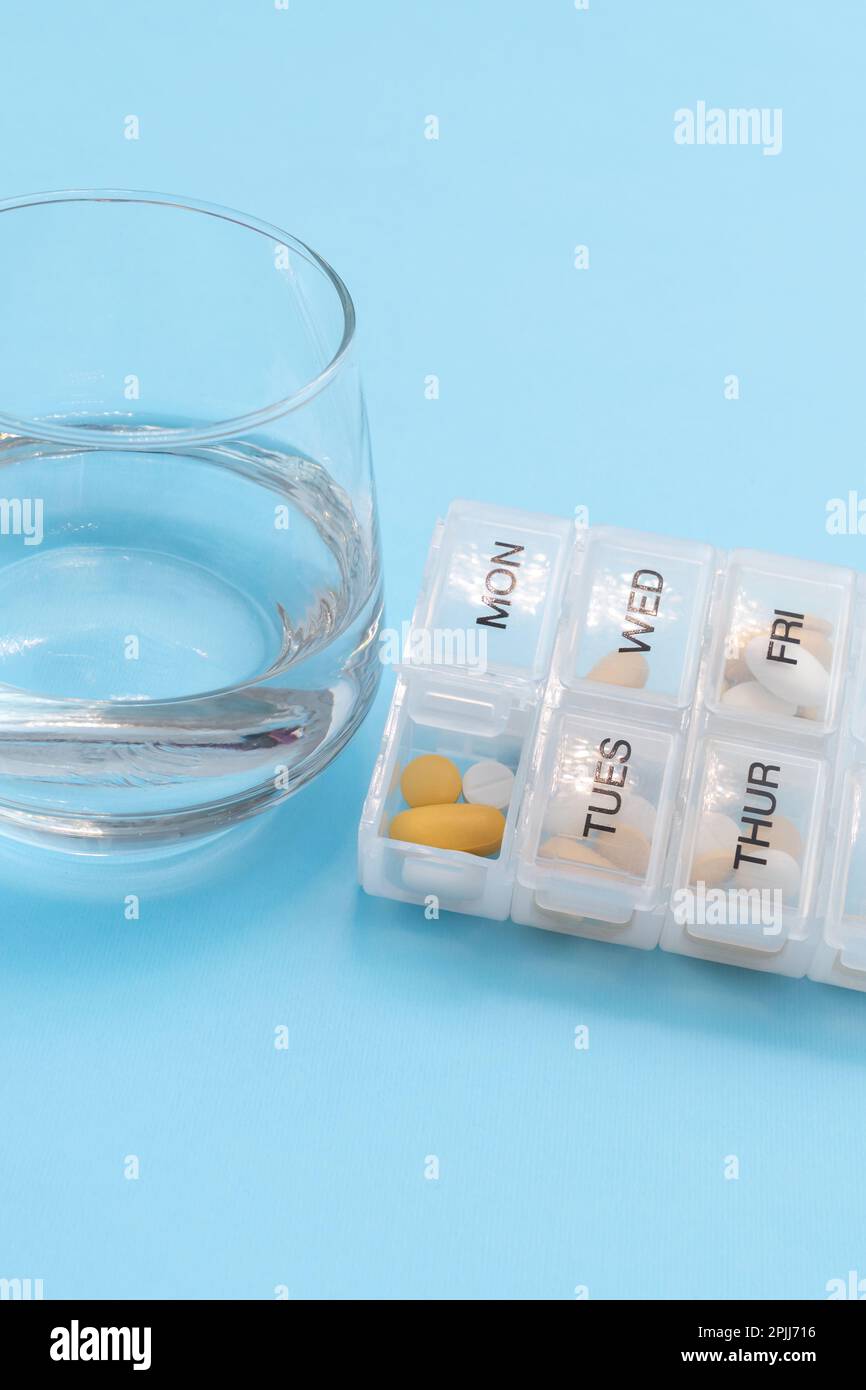Weekly pill organizer with sunday open compartment and glass of water ...